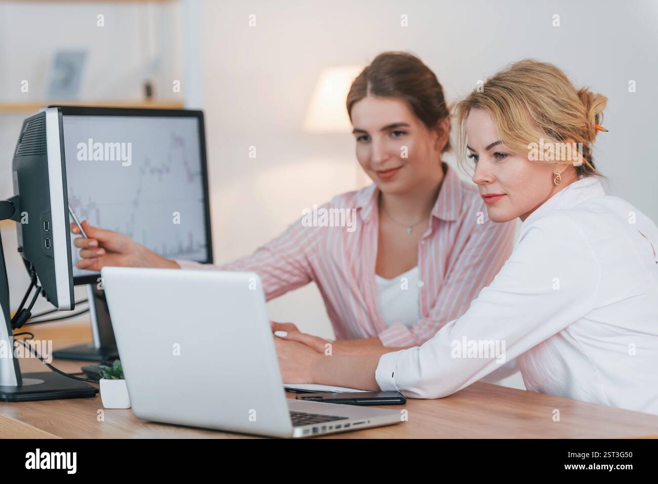 Talking with each other. Two female stock brokers in formal wear is ...
