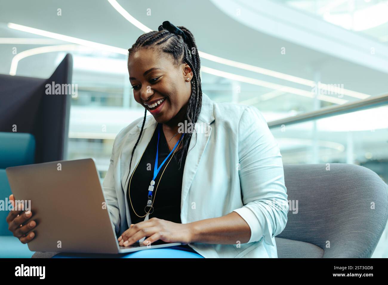 A confident female financial advisor smiles while working on a laptop ...