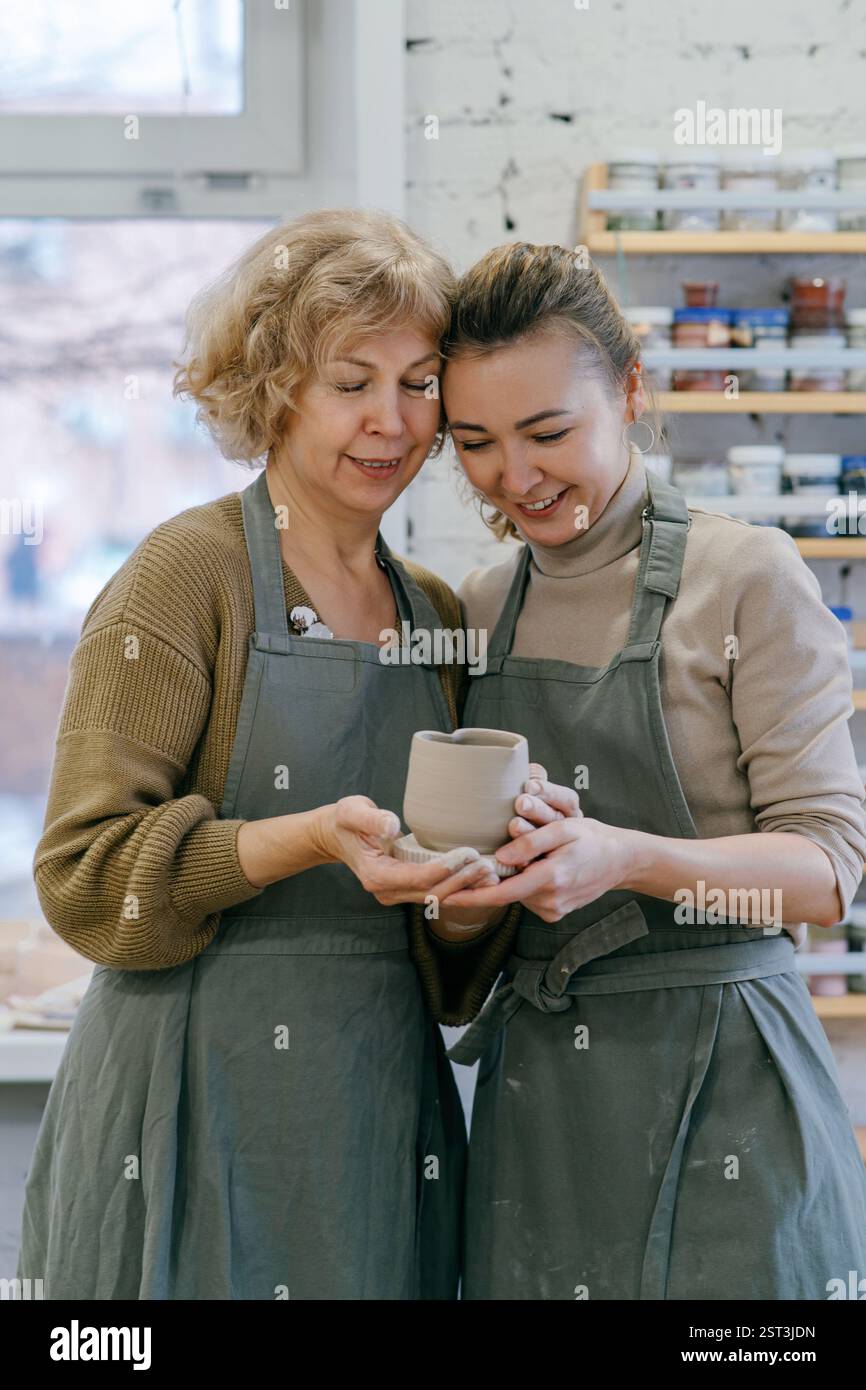 Two generations of women proudly presenting self-made pottery after ...