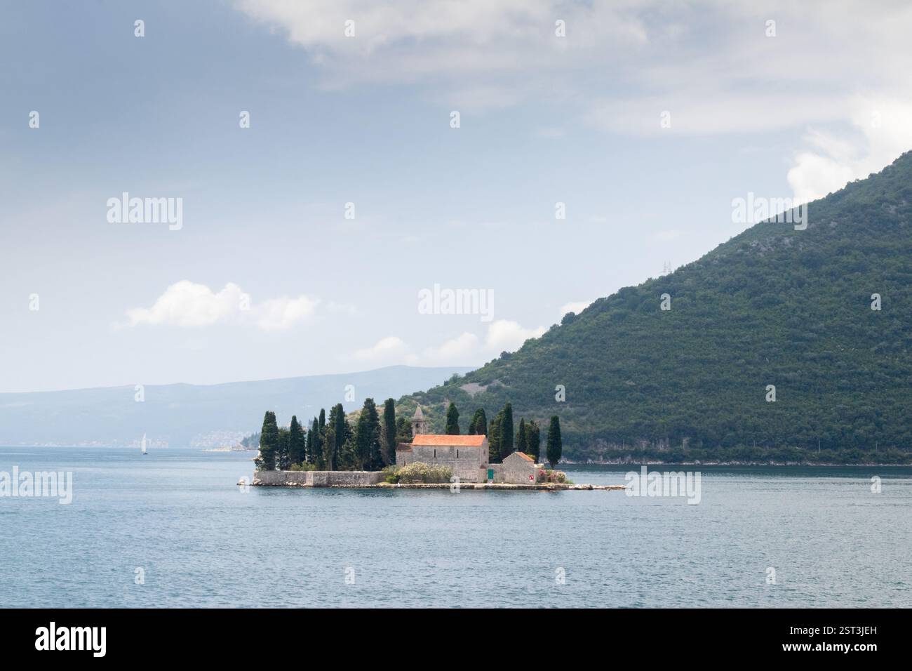 A serene view of an island featuring a historic church amidst calm bay ...