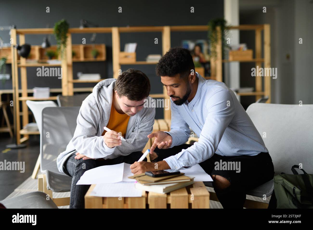 Young man with Down syndrome studyng with special educator teacher in ...
