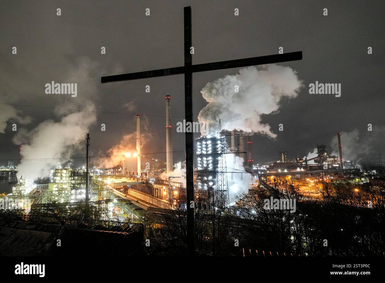 FILE - A cross can be seen in front of the steaming Schwelgern coking ...