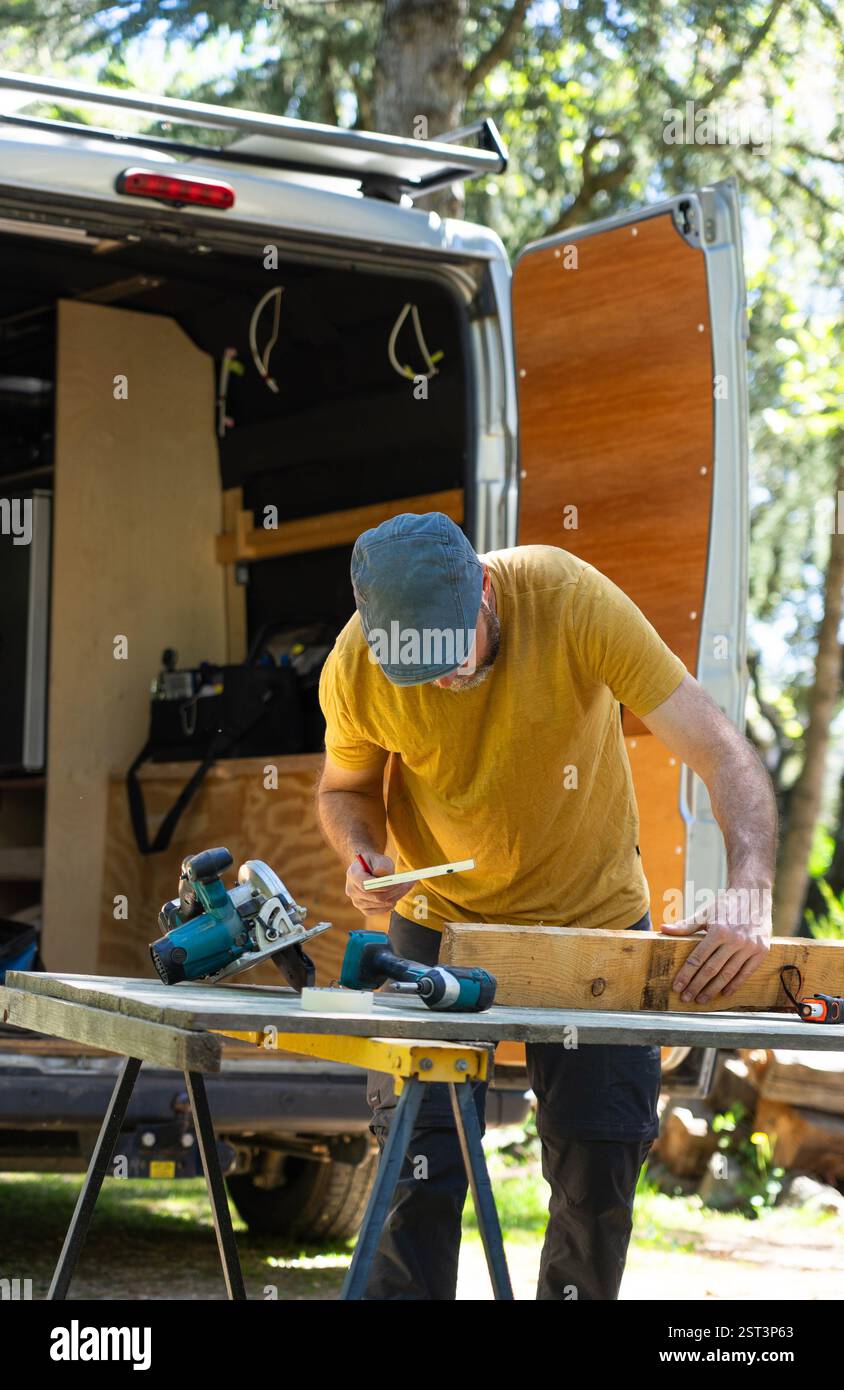 Carpenter taking measurements of wooden plank using ruler and pencil ...