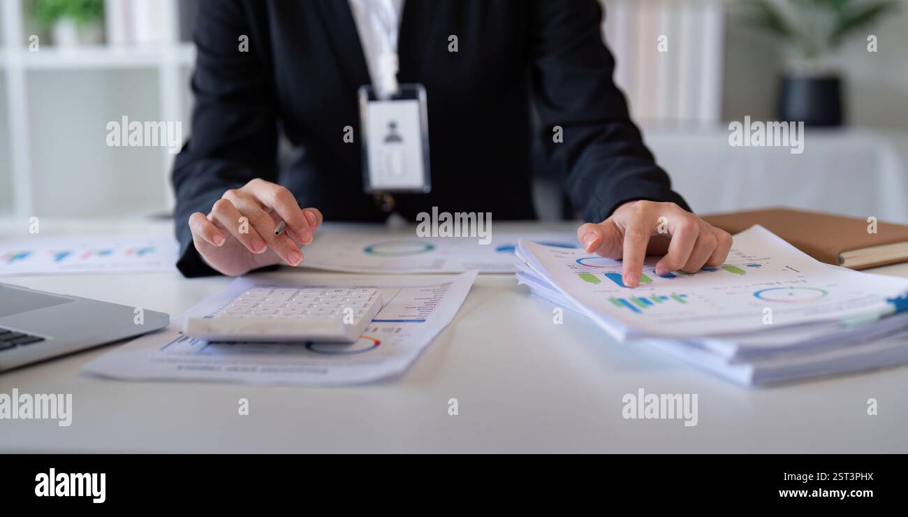 Accountant calculating financial data with a calculator and reviewing ...