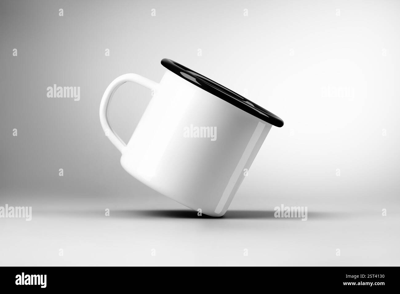 Mockup of enamel white mug with black rim, handle, shadows ...