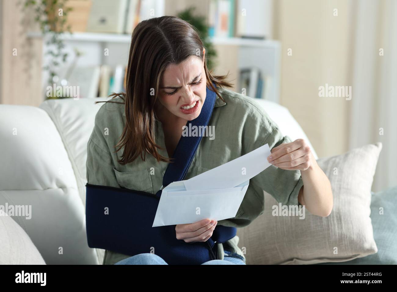 Angry convalescent woman reading bad news on letter at home Stock Photo ...