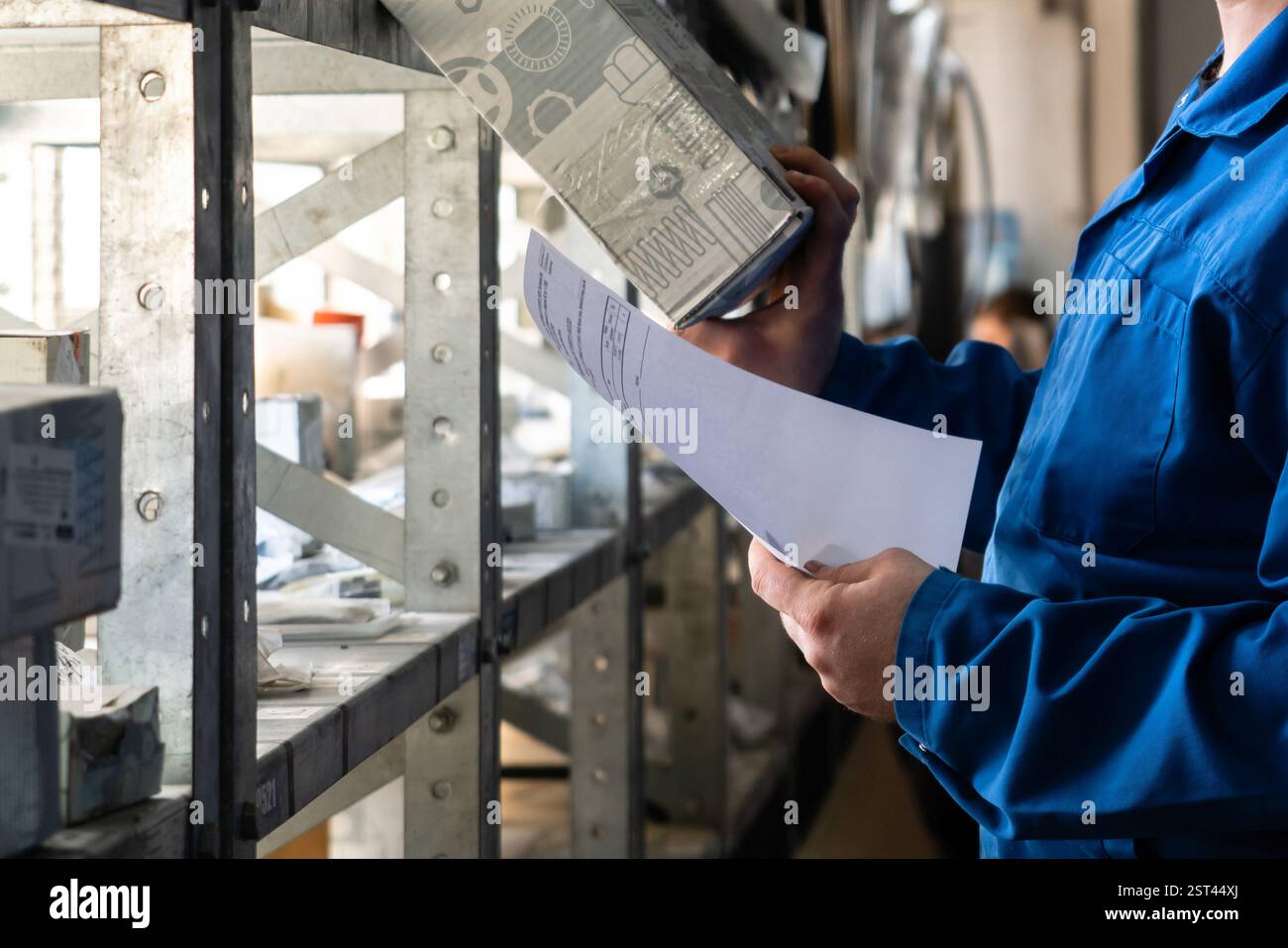 Worker works in a spare parts warehouse Stock Photo - Alamy
