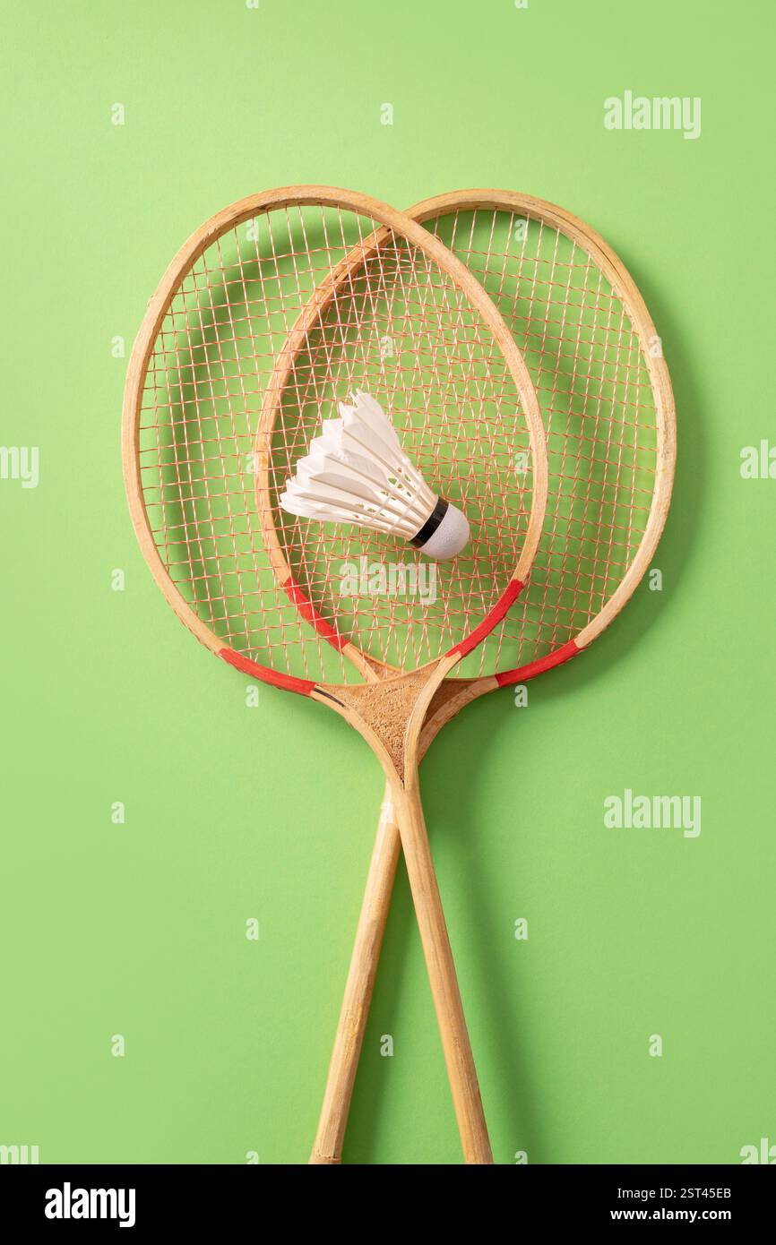 Two wooden badminton rackets and white feather badminton shuttlecock on ...