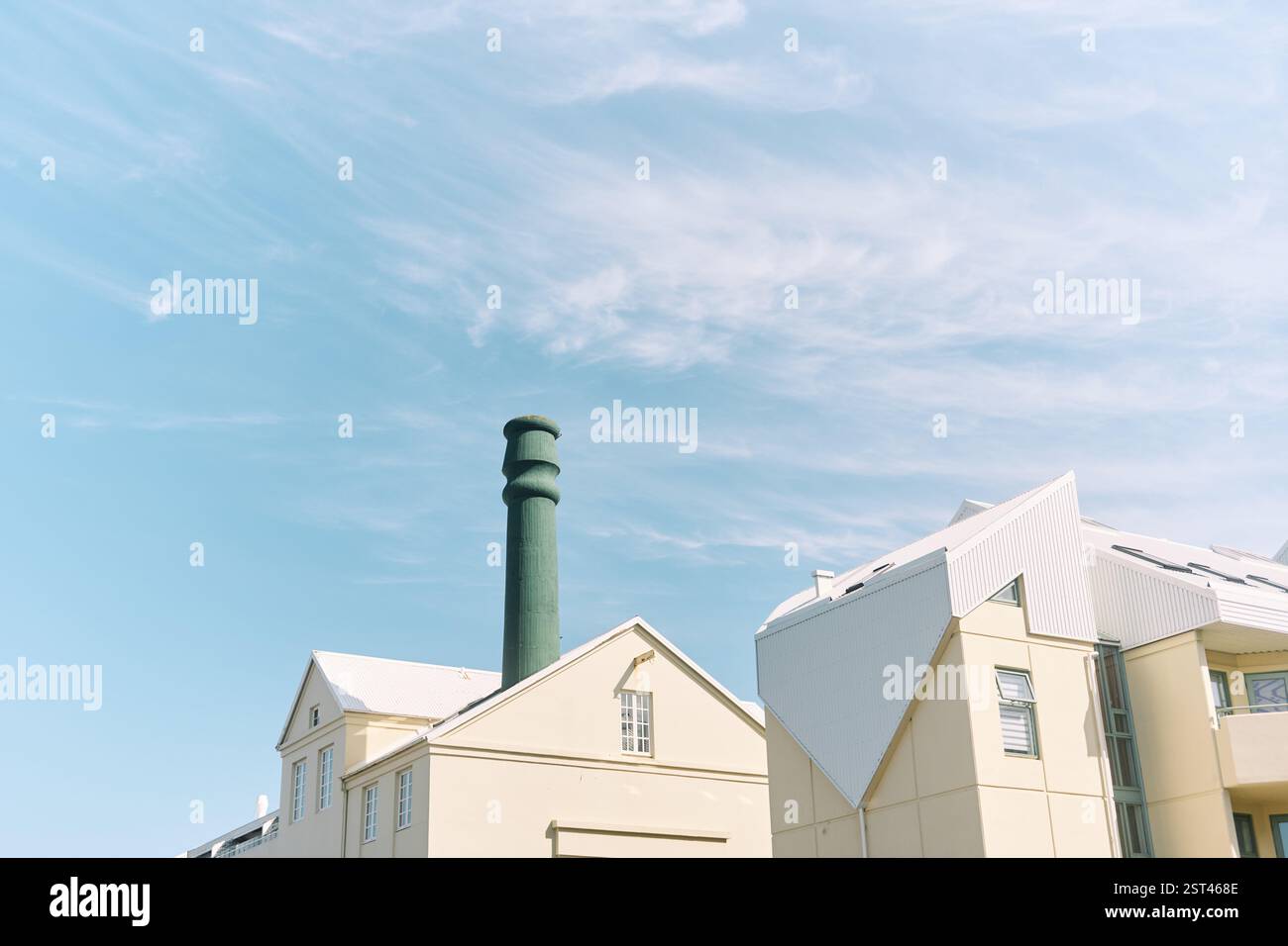 Industrial chimney towering over modern residential buildings Stock ...