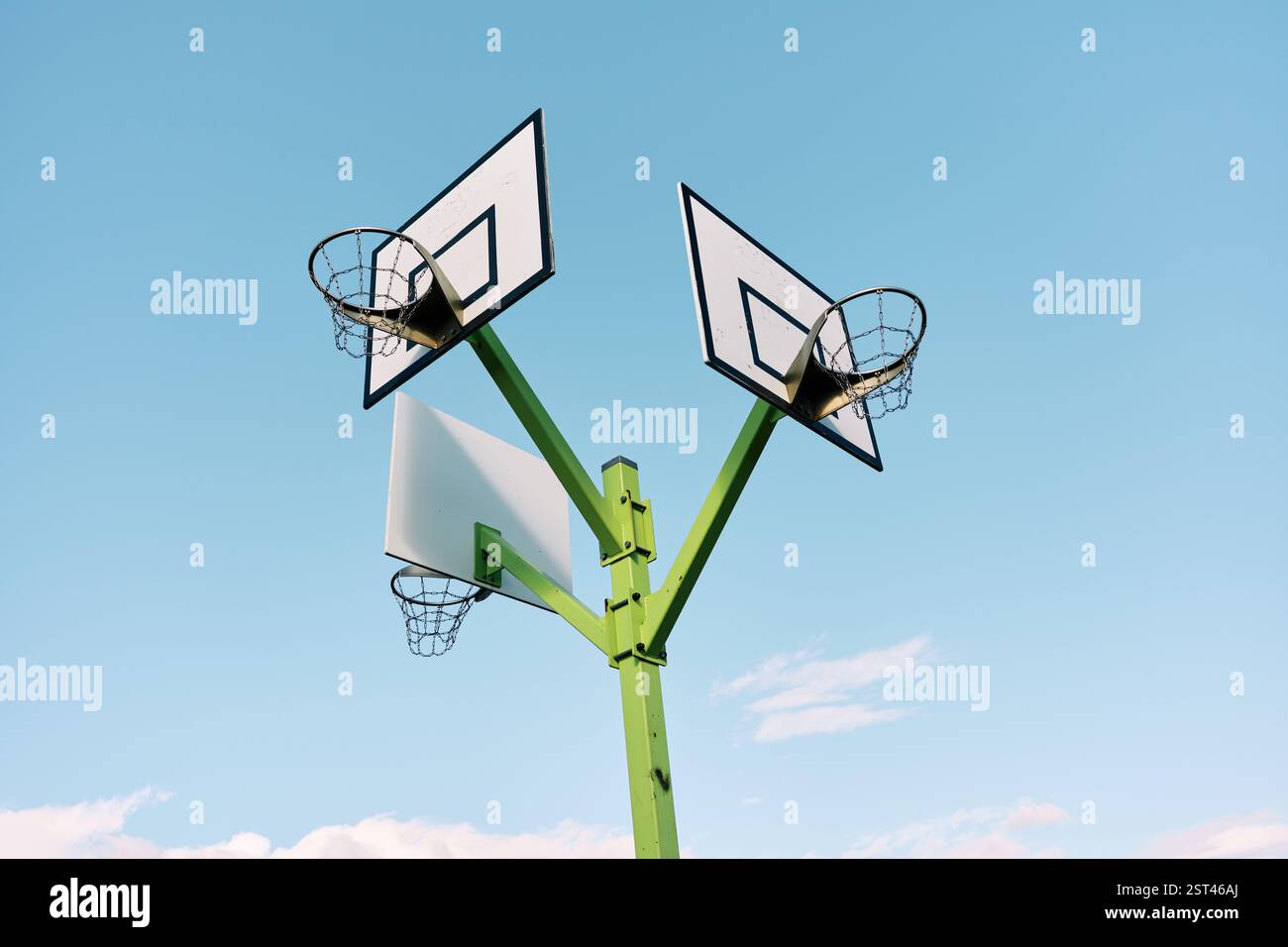 Three basketball hoops pointing in different directions under blue sky ...