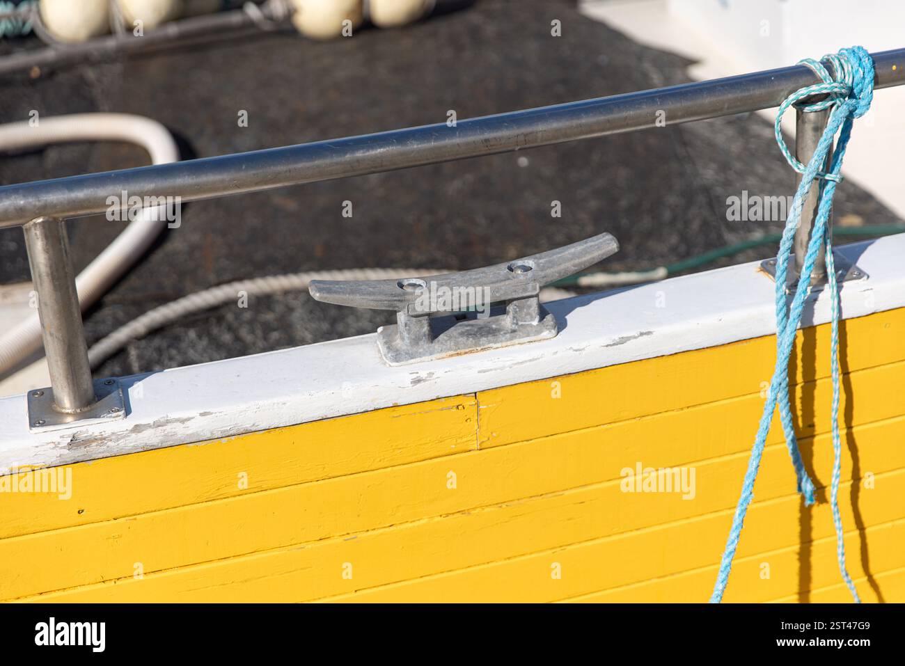 Metal boat cleat and blue rope on a yellow and white boat Stock Photo ...