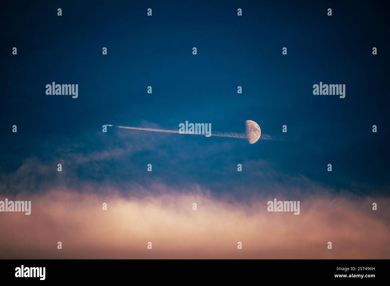 Airplane Leaving a Contrail Across the Half Moon in the Twilight Sky ...
