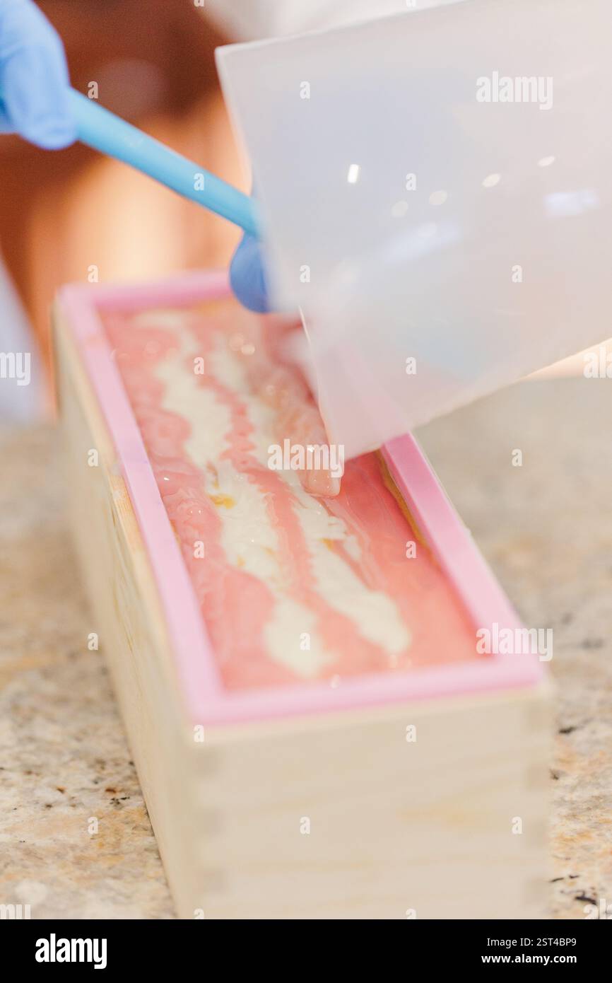 Close-up of final soap layer being poured into a swirled mold design ...