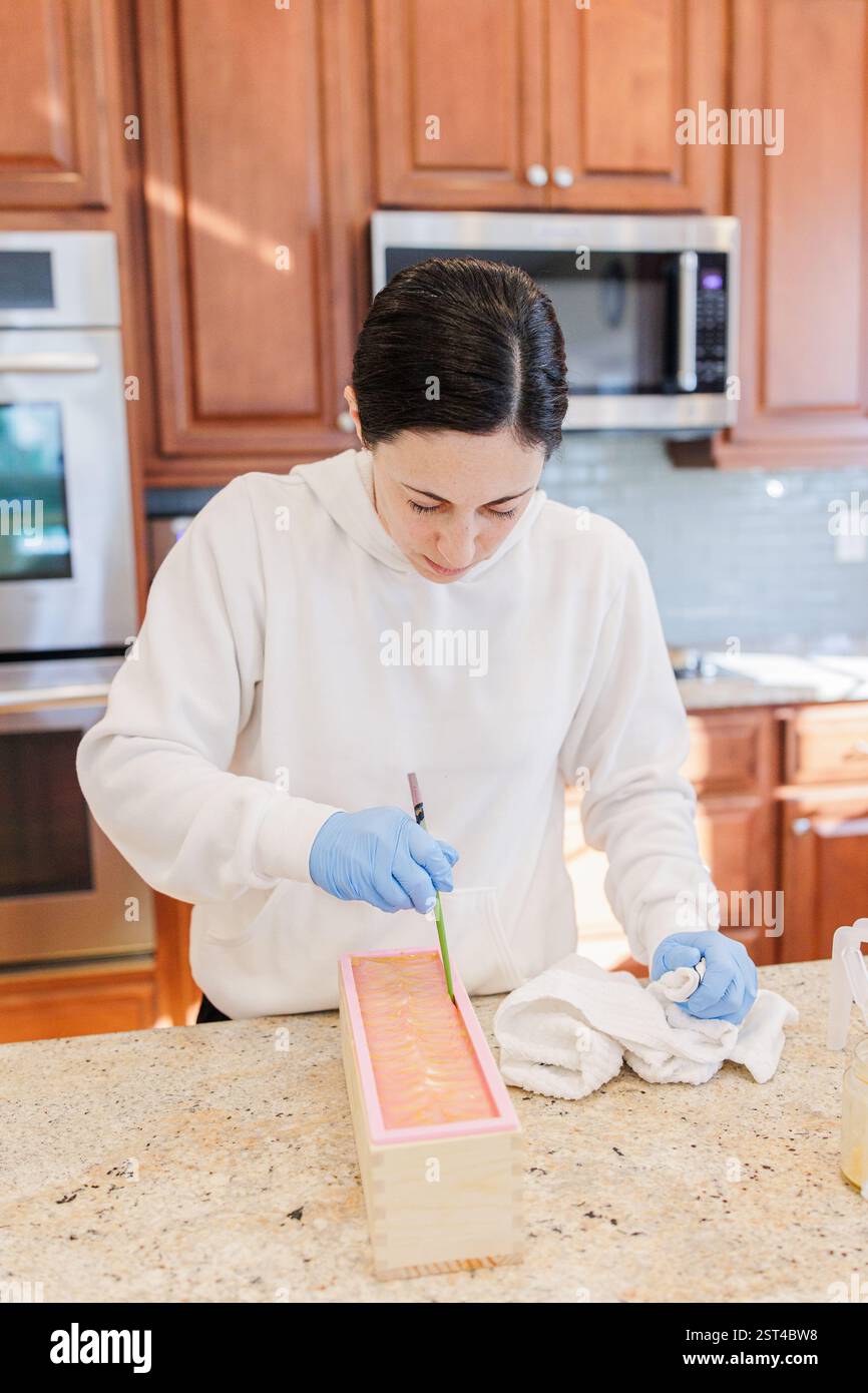 Artisan adding final swirl designs to handcrafted soap in mold Stock ...