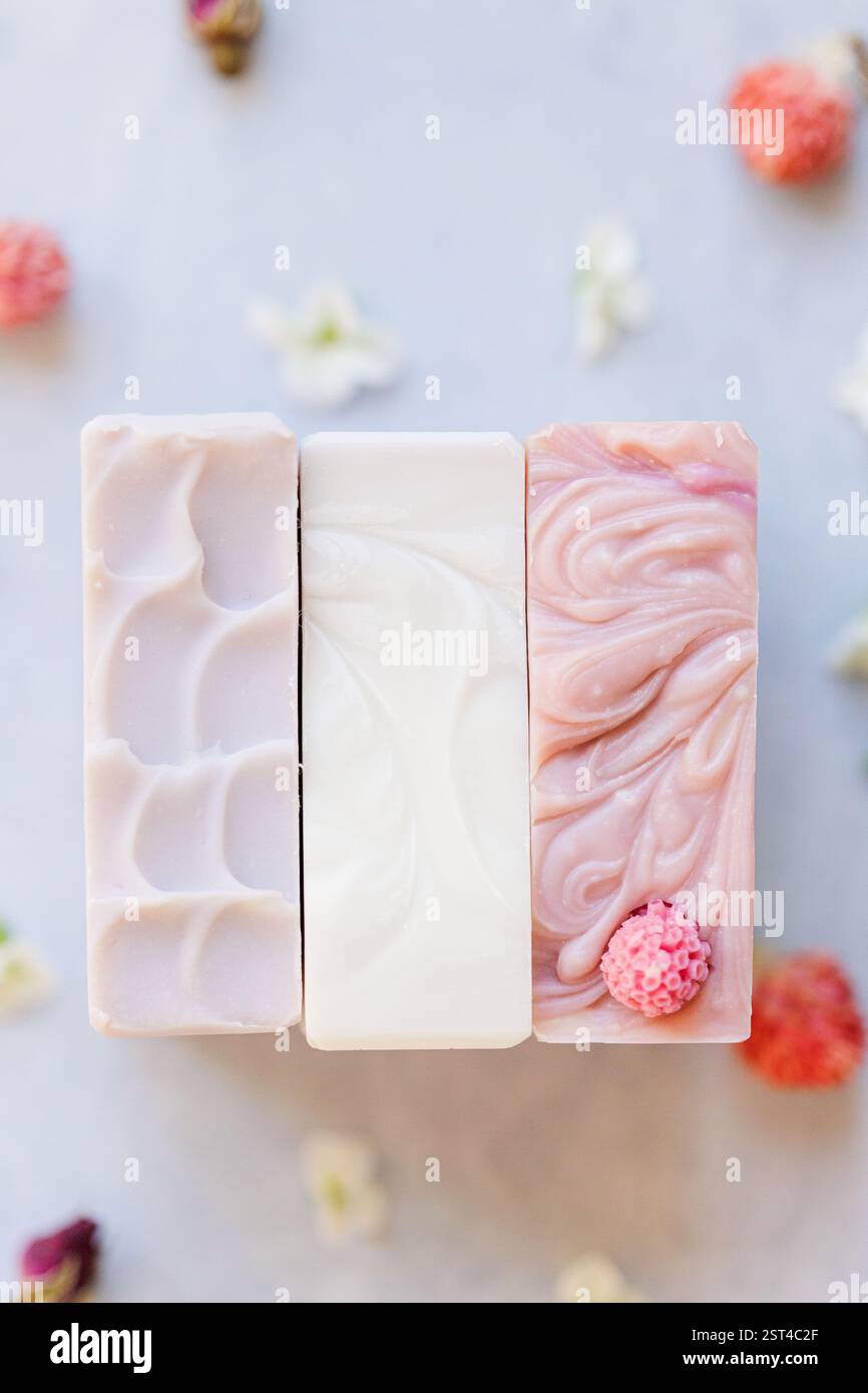 Three artisan soaps with elegant swirls and a decorative raspberry ...