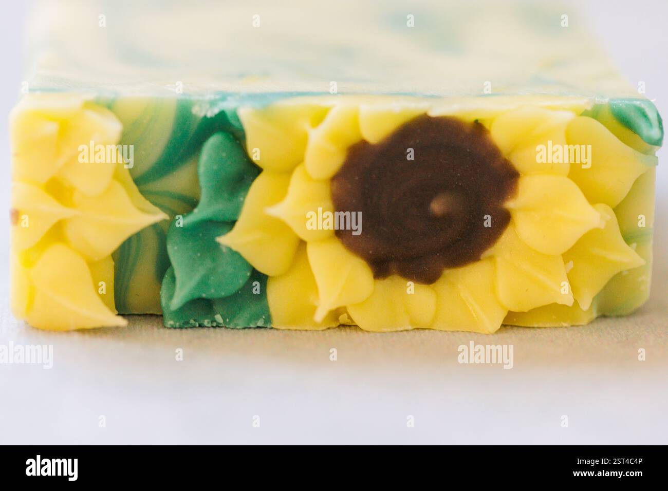 Handmade soap with a sunflower design and swirled green details Stock ...