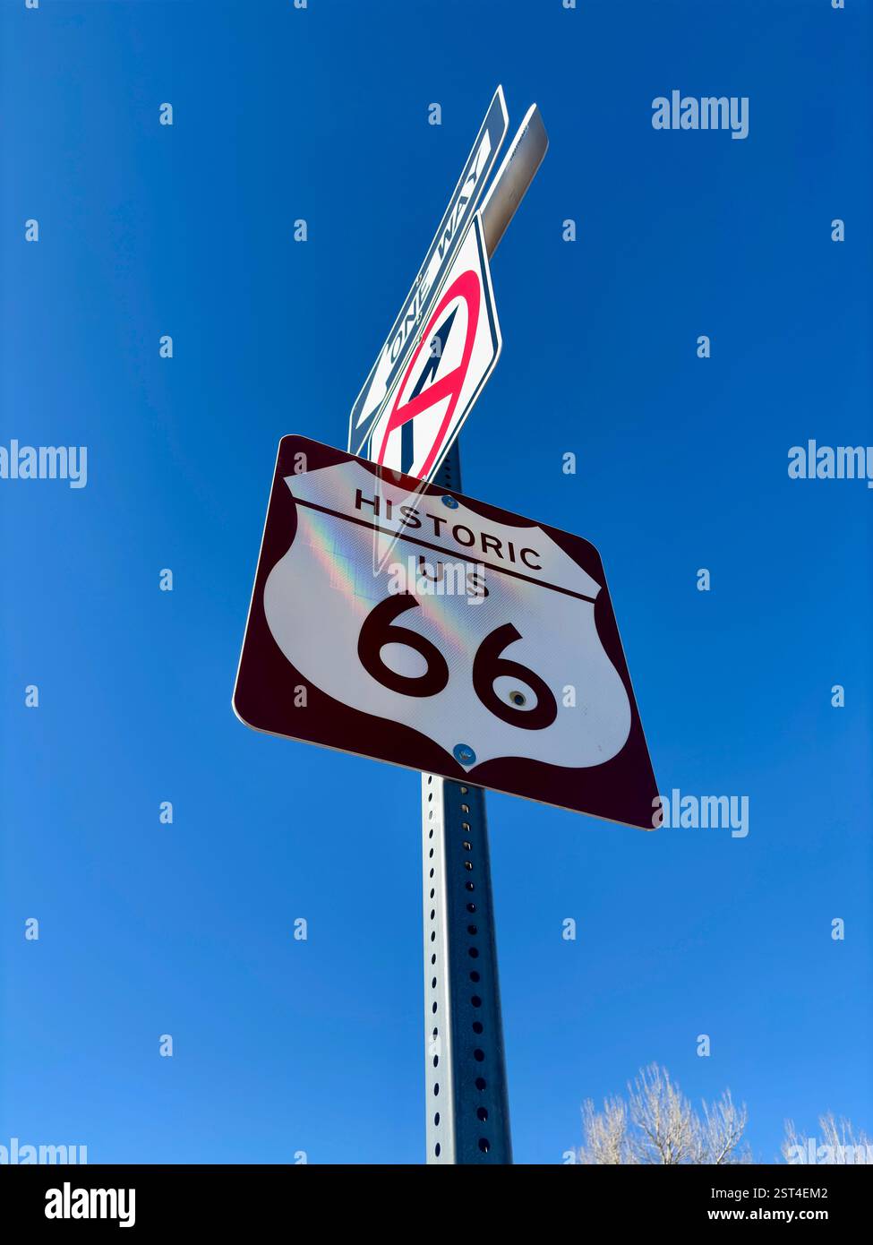 Historic Route 66 sign with additional road signs against a blue sky ...