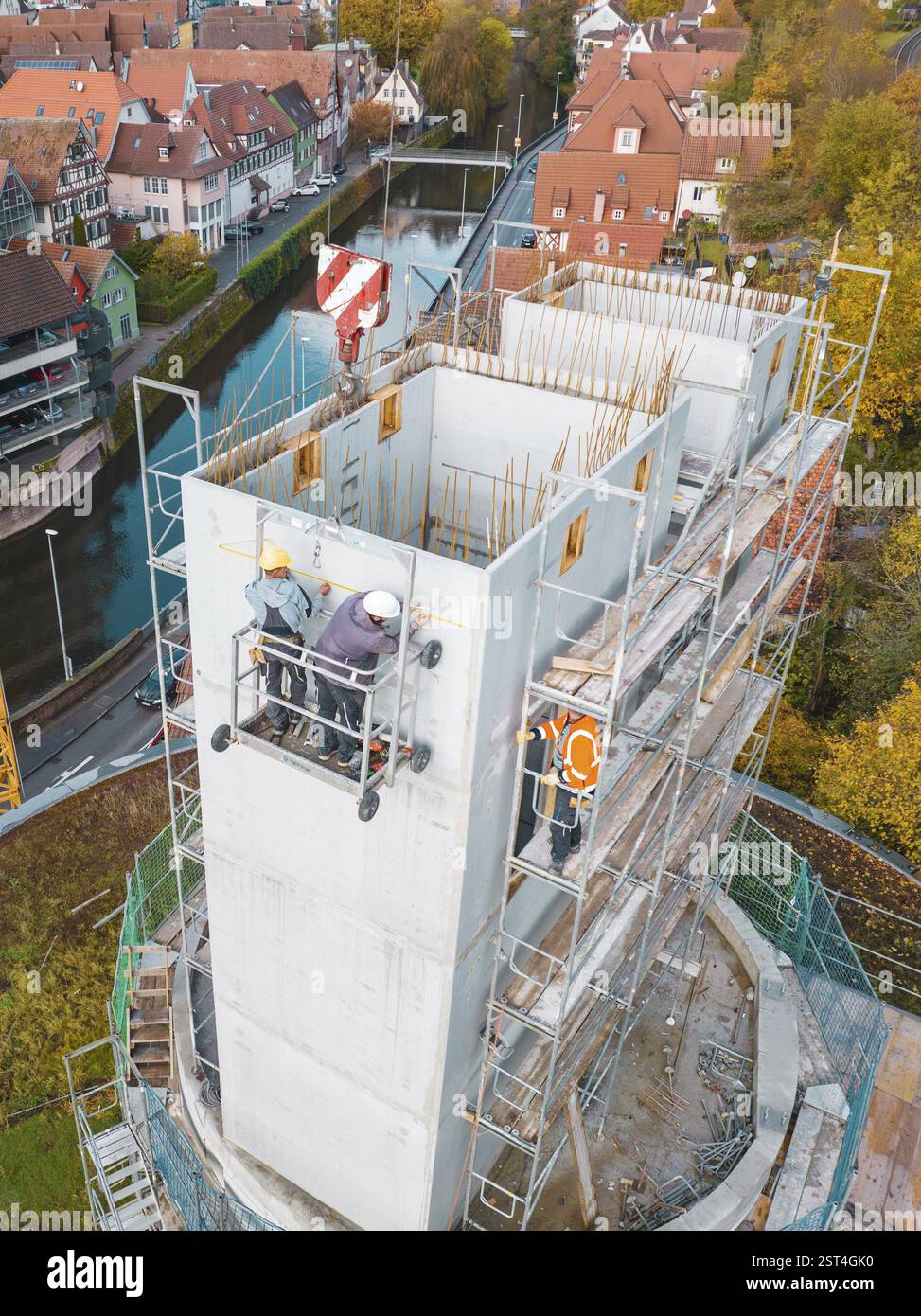 Workers working on a concrete tower next to a river and picturesque ...