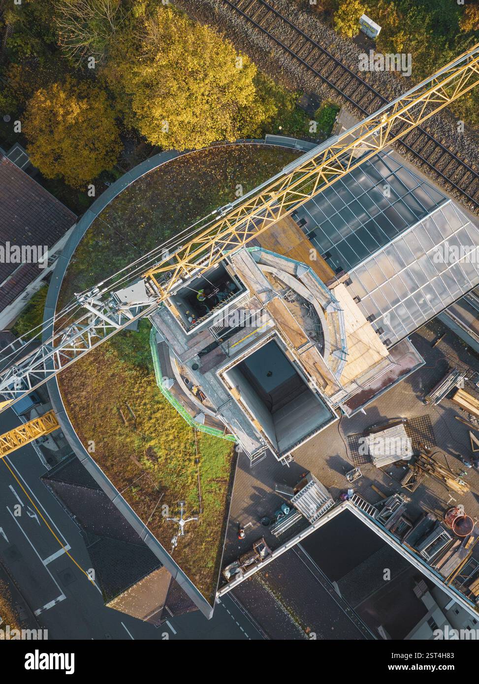 Bird's eye view of a construction site with crane and adjacent railway ...