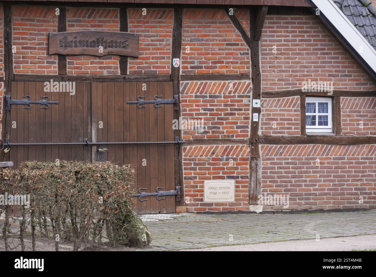 Large wooden gate in a brick wall with a name plate, weseke ...