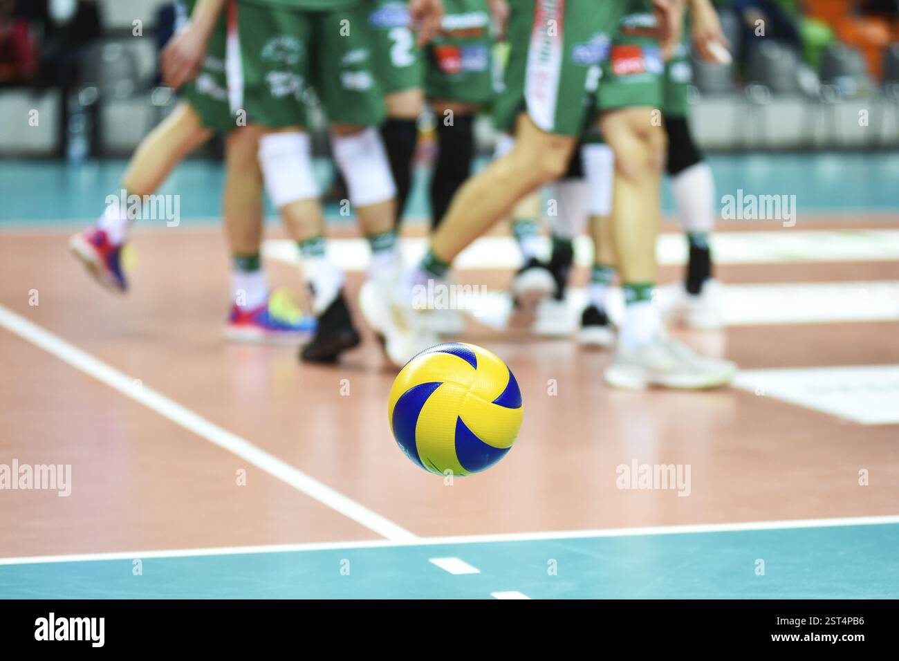 Volleyball ball flying near the pitch with players in the background ...