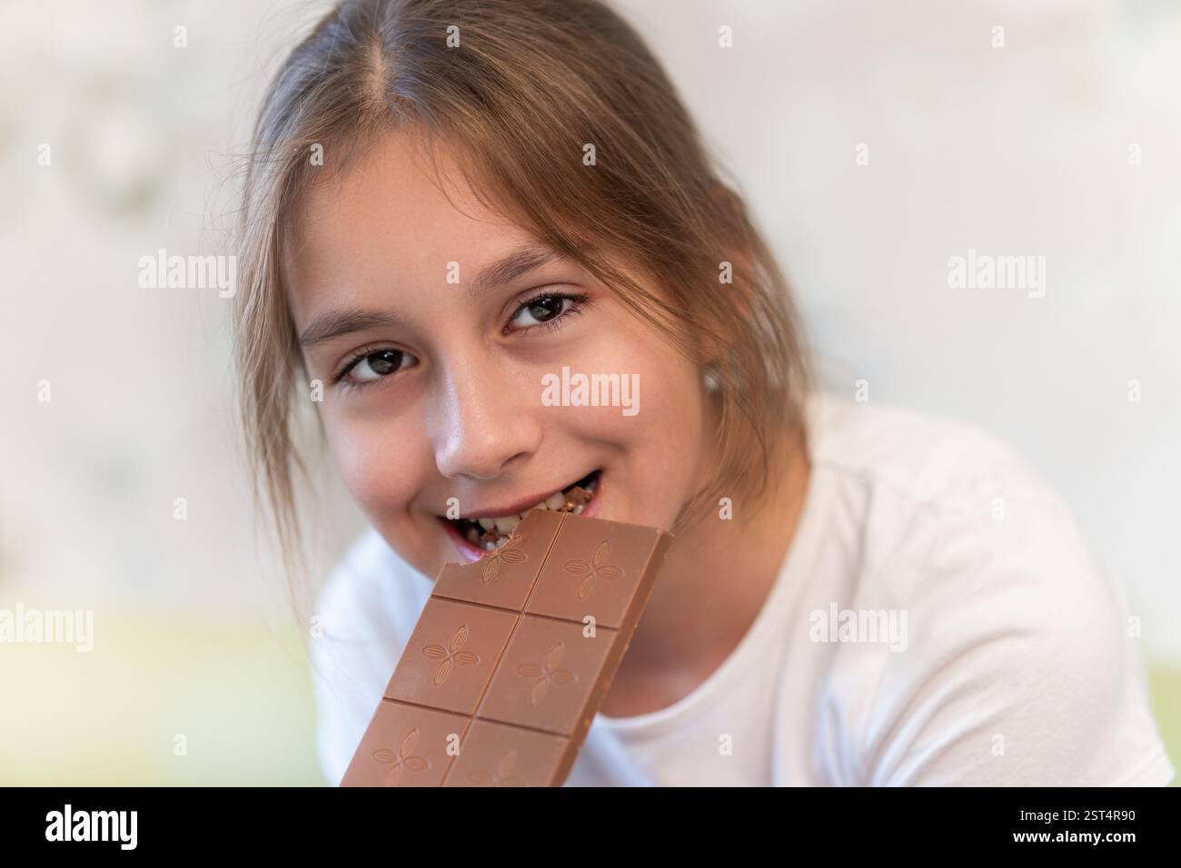Addiction of sweets and candies. A girl bites a chocolate with her ...