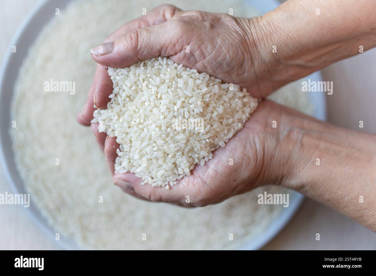 Rice paddy falling from hand hi-res stock photography and images - Alamy