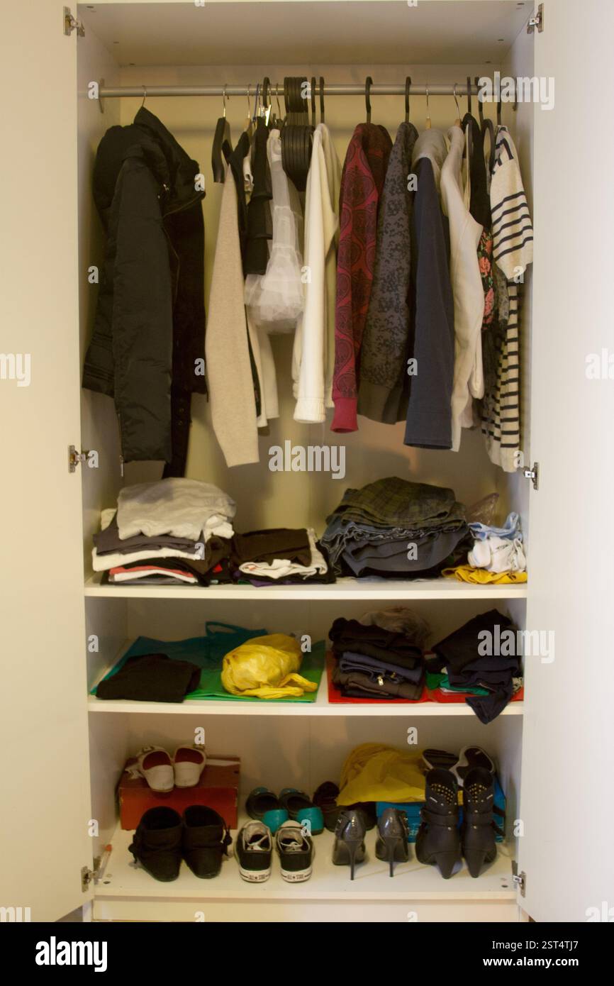 Open wardrobe revealing organized clothes and shoes. Storage solutions, closet organization, and ...