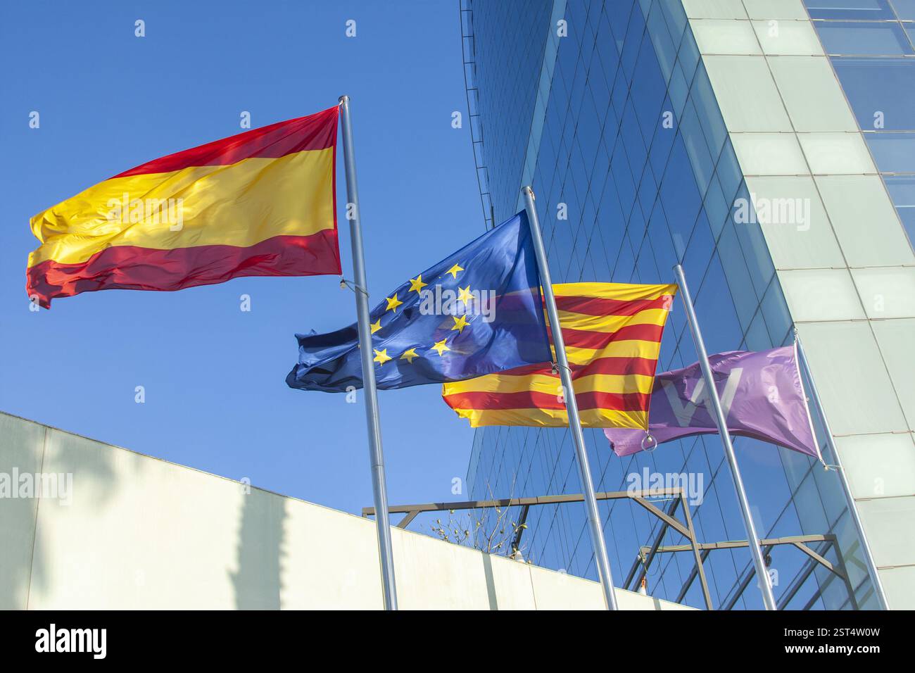 A set of flags waving in the wind against the backdrop of a modern ...