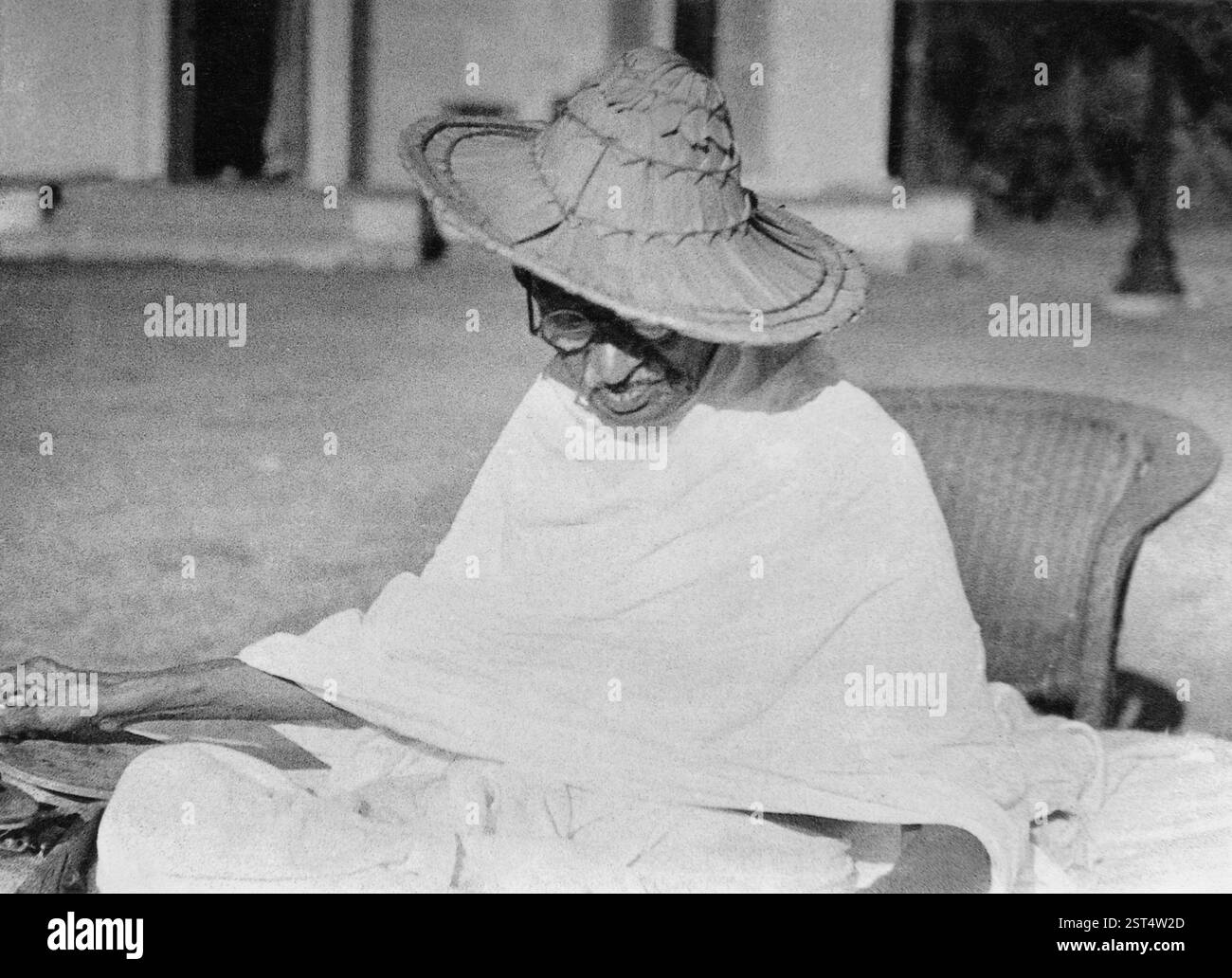 Mahatma Gandhi wearing a Noakhali hat whilst spinning at Birla House, New Delhi, India, November ...