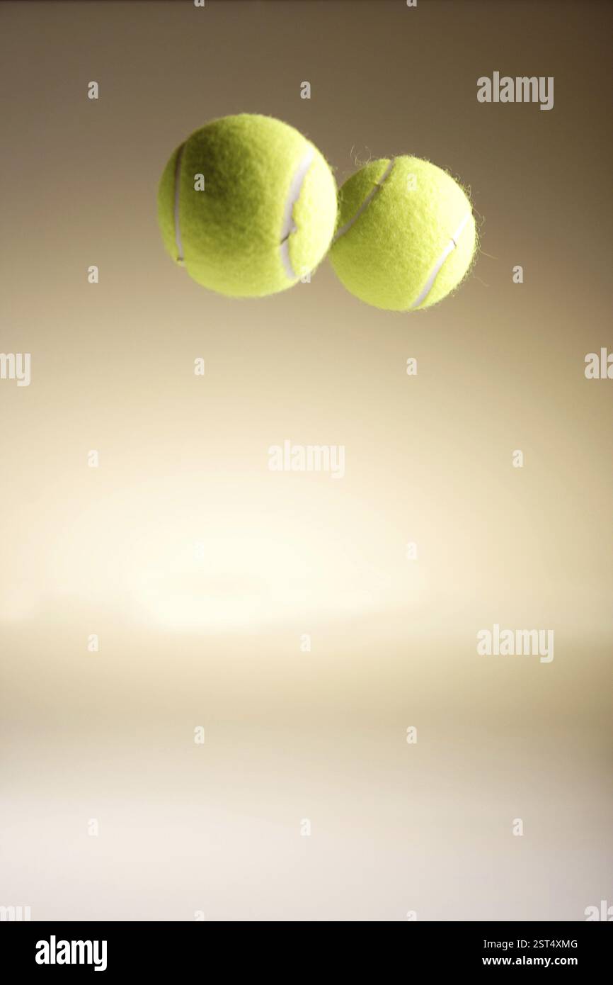 Two tennis balls green color bouncing in air Stock Photo - Alamy