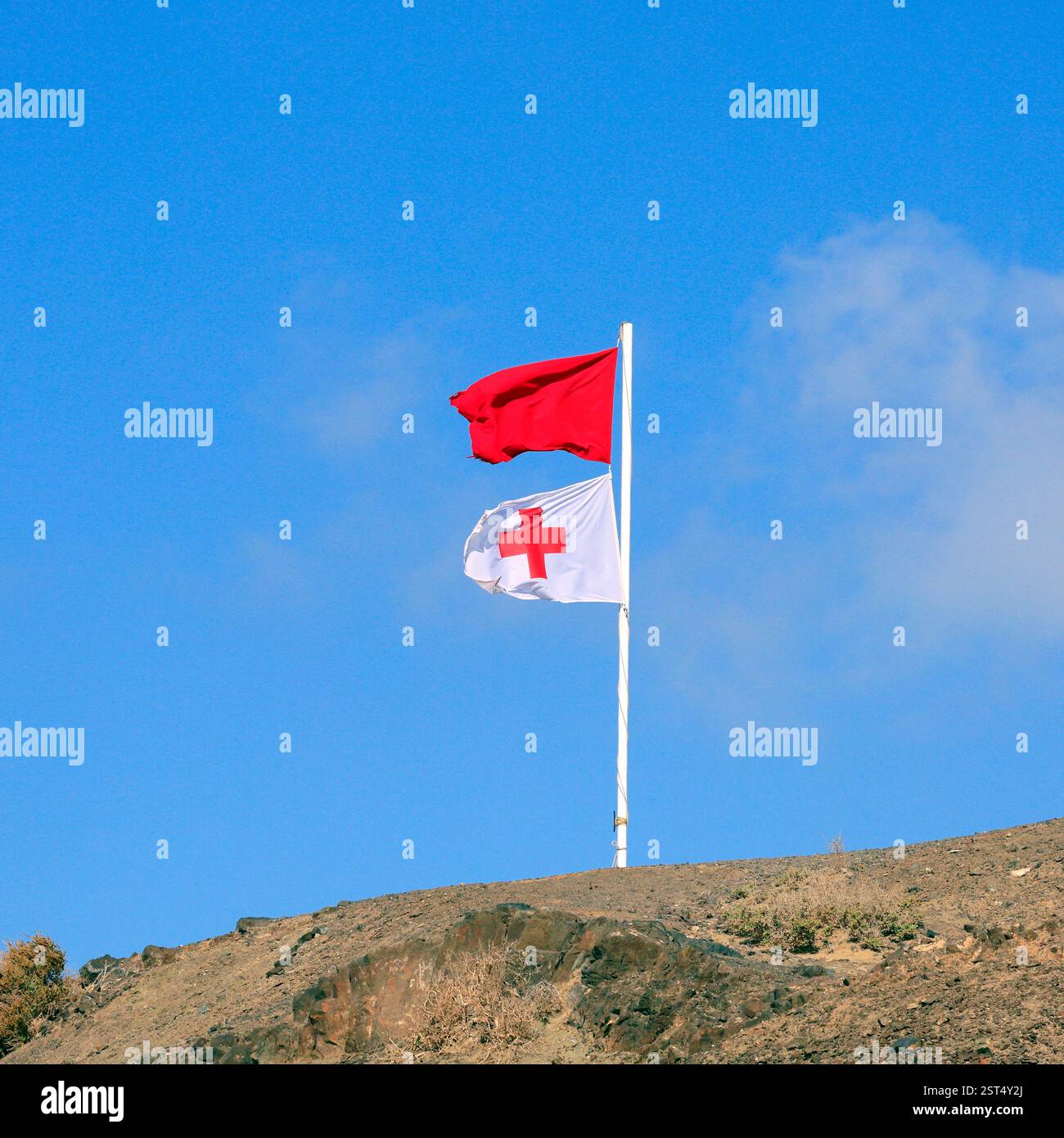 Red warning swimming flag and cruz roja flag at lifeguard station ...