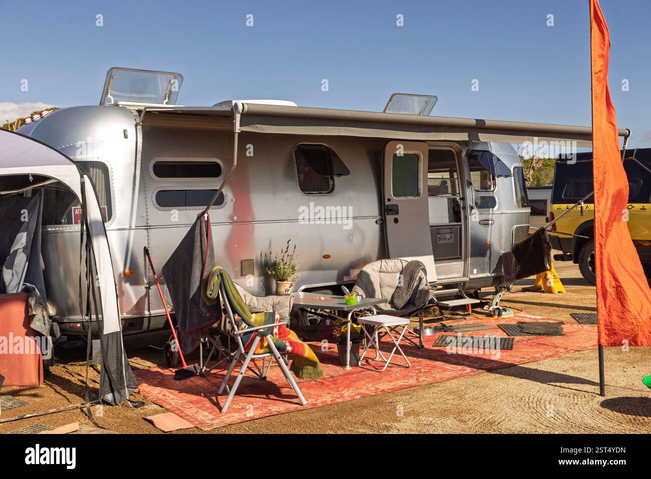 Vintage Airstream camper parked at a campsite with outdoor setup ...