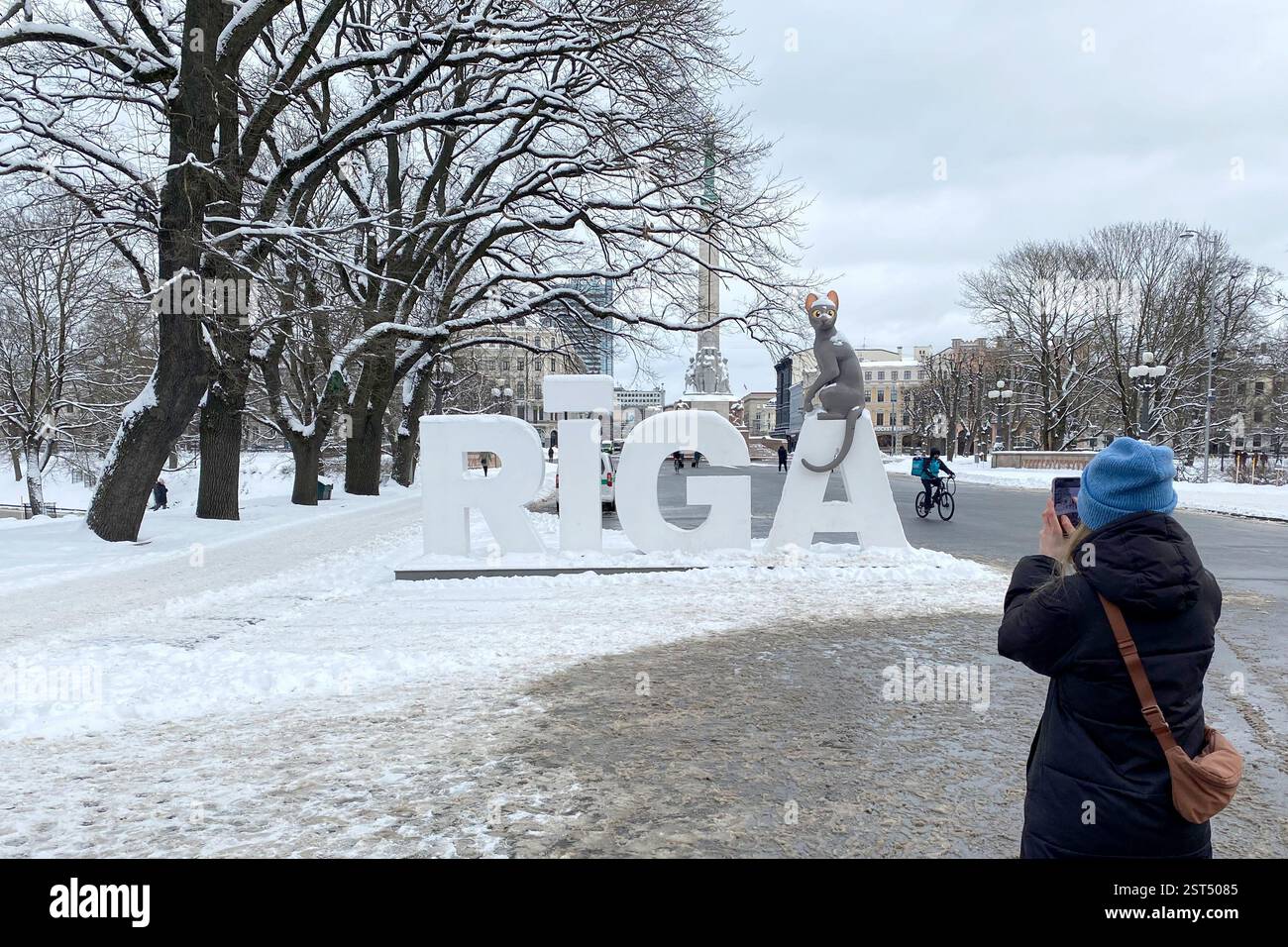 Riga, Latvia. 17th Feb, 2025. A woman photographs the Riga lettering on ...