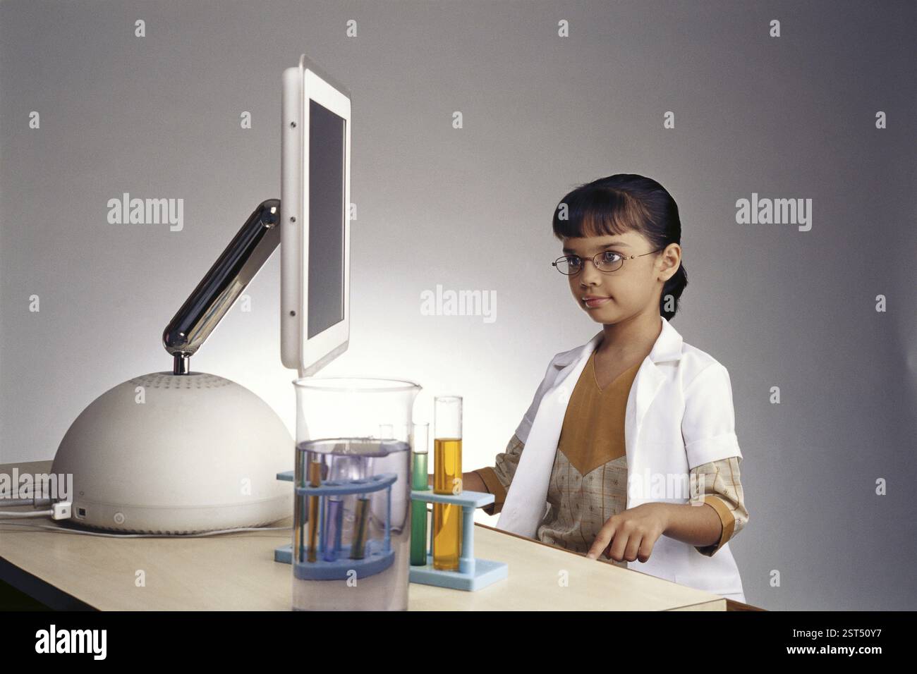 Child dressed as scientist, girl working on Apple Macintosh Computer ...