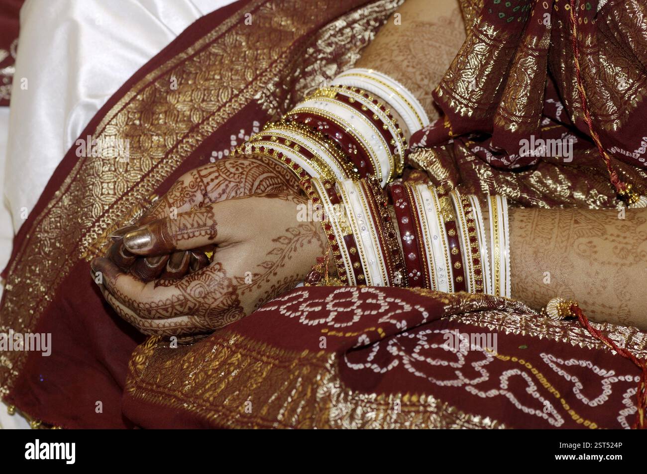 South Asian Indian Bride wearing golden bangles and showing mehandi in ...