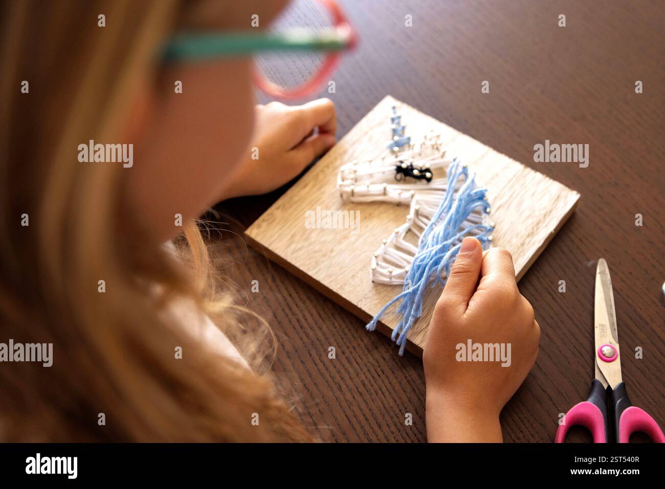 Child hands working on a string art project. Encouraging creativity ...