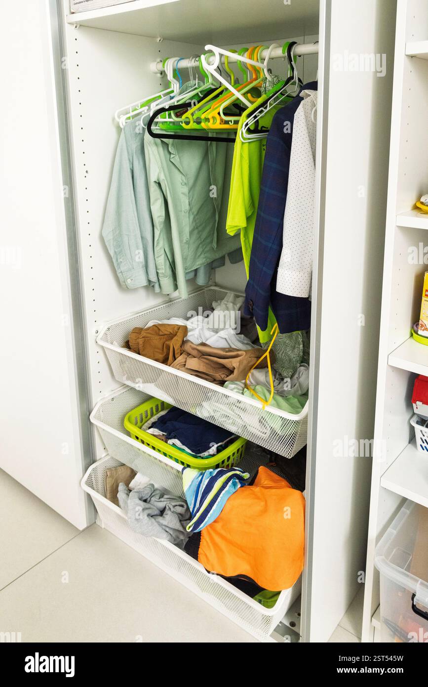 Boy wardrobe with neatly hung clothes and mesh baskets for organized ...