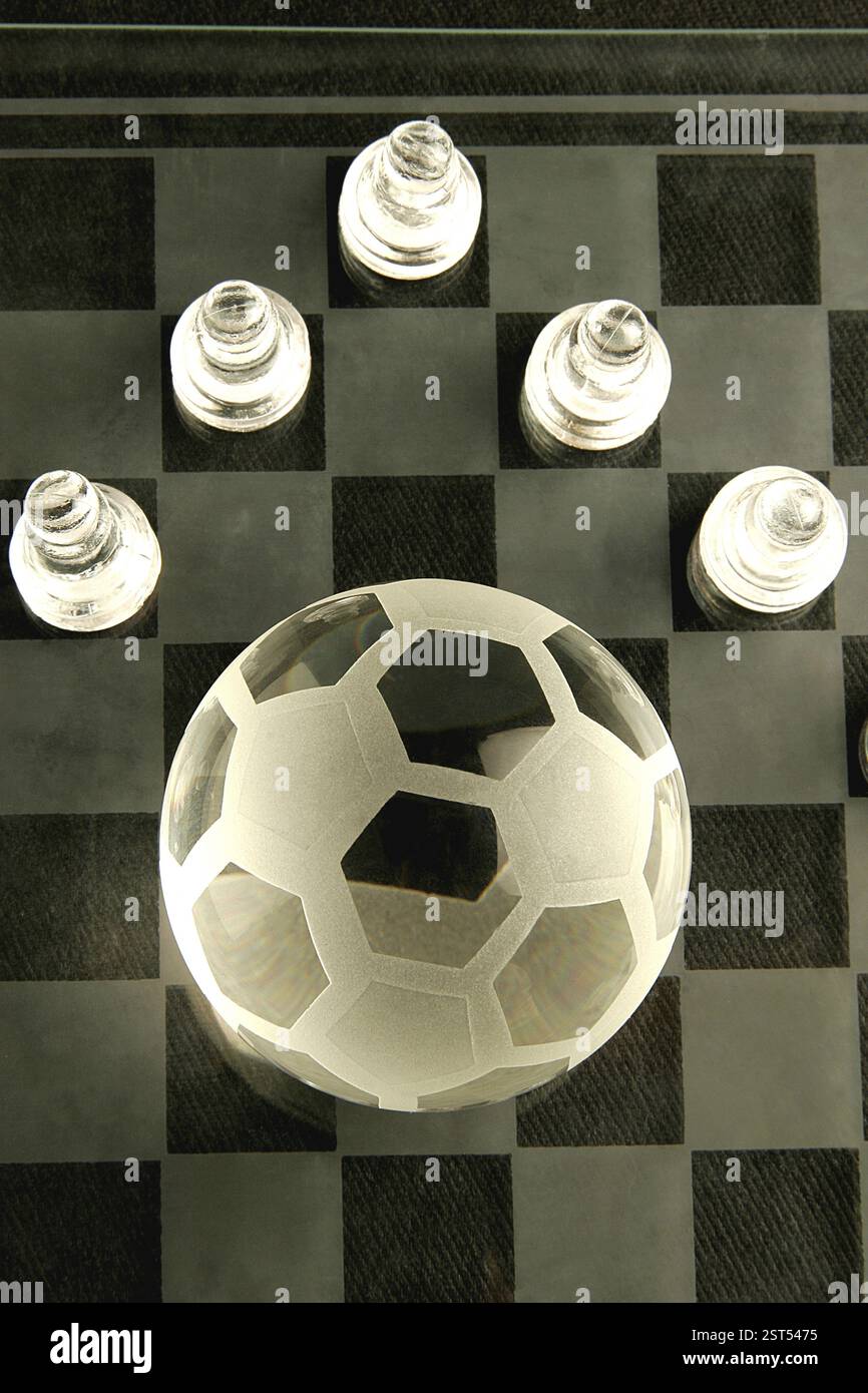 Ball of football made of glass on glass chess board with its pawns as ...