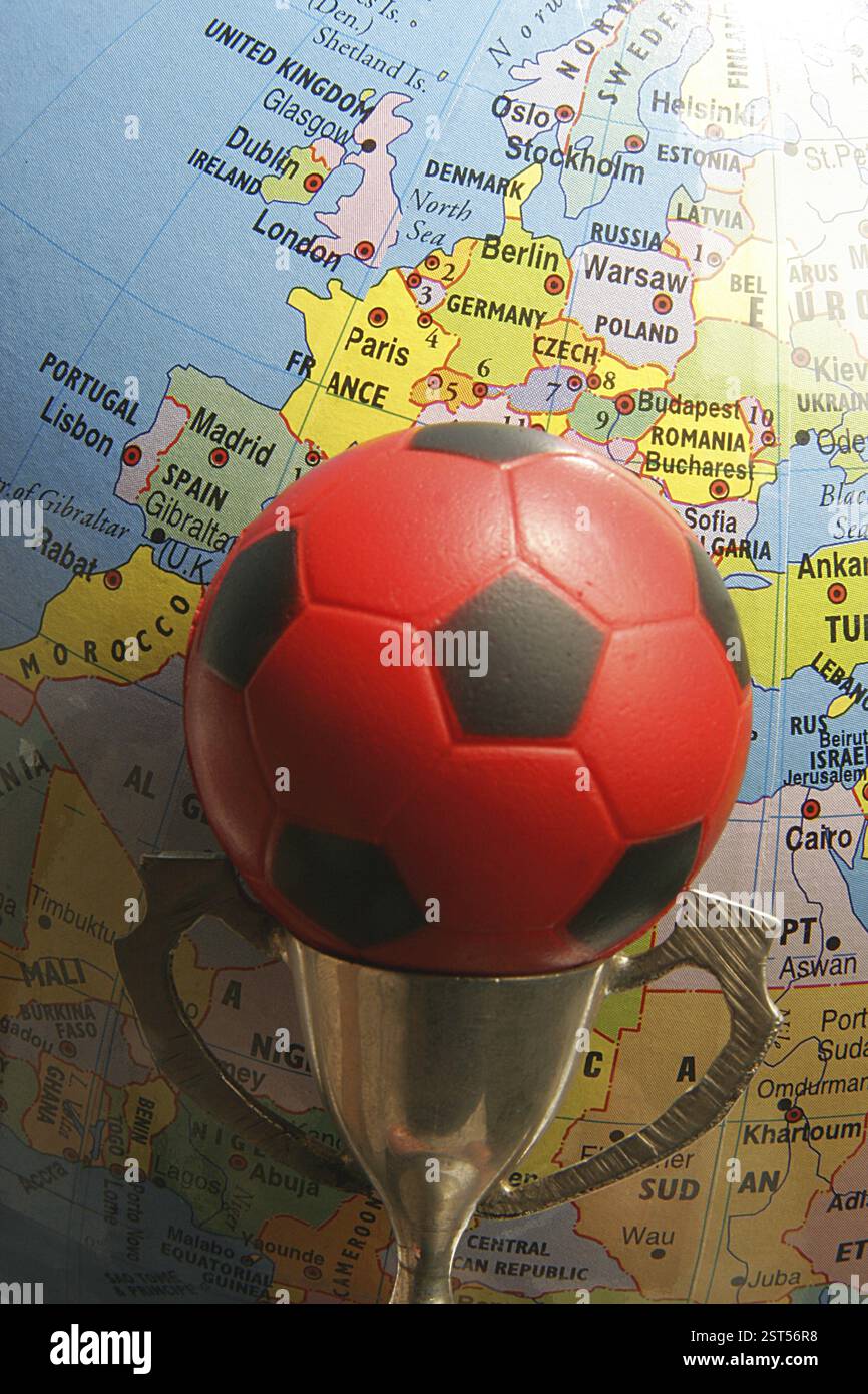 Small metal cup with red and black rubber ball of football sport and ...