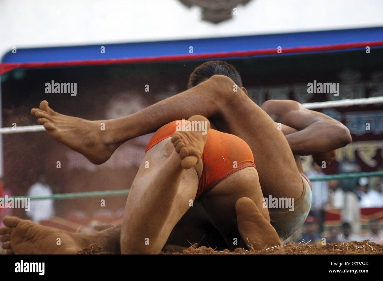 Two men grappling in only undergarments in sand pit at Olympics sport ...