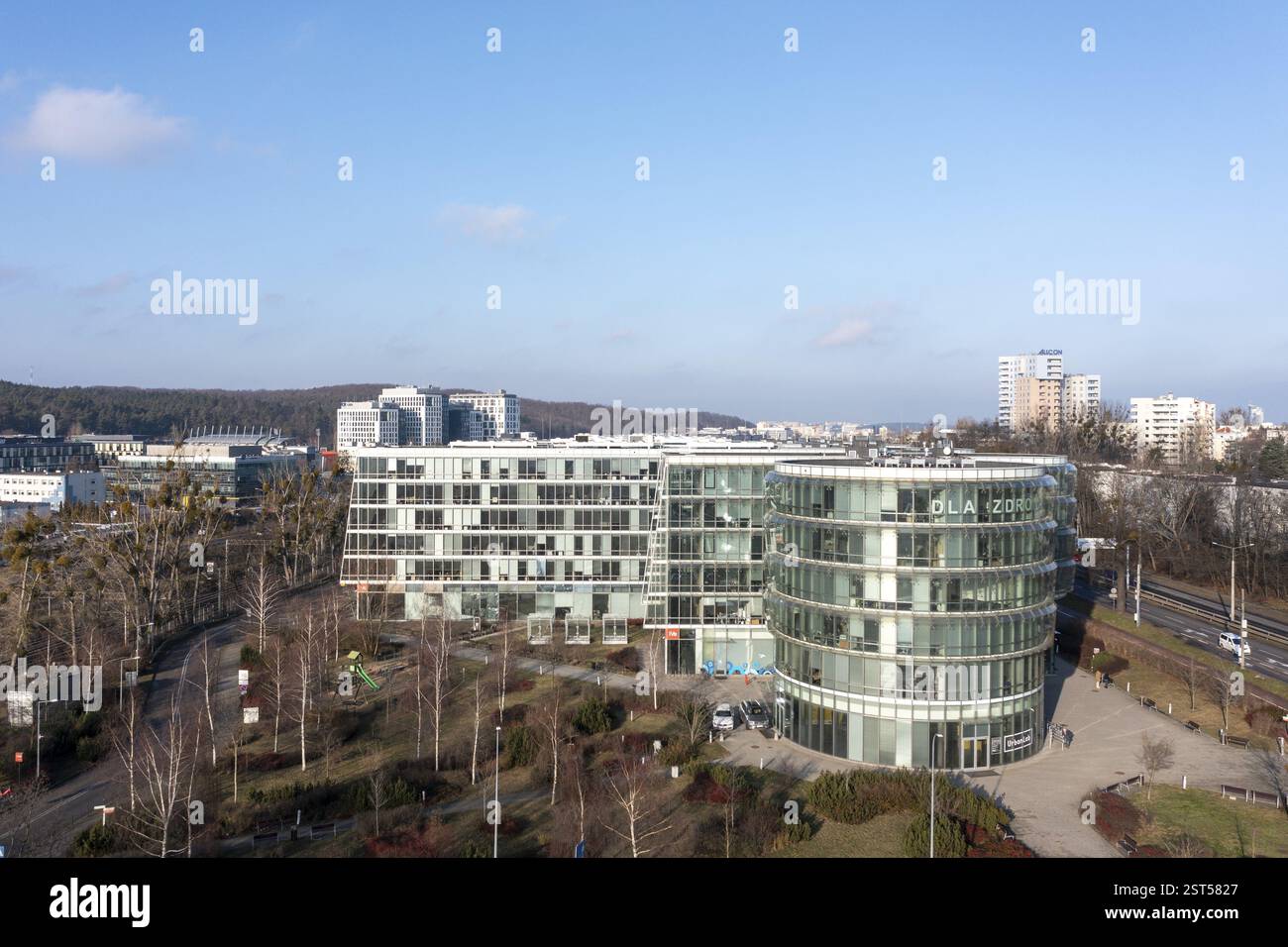 Curved modern building with glass facade surrounded by greenery. Modern ...