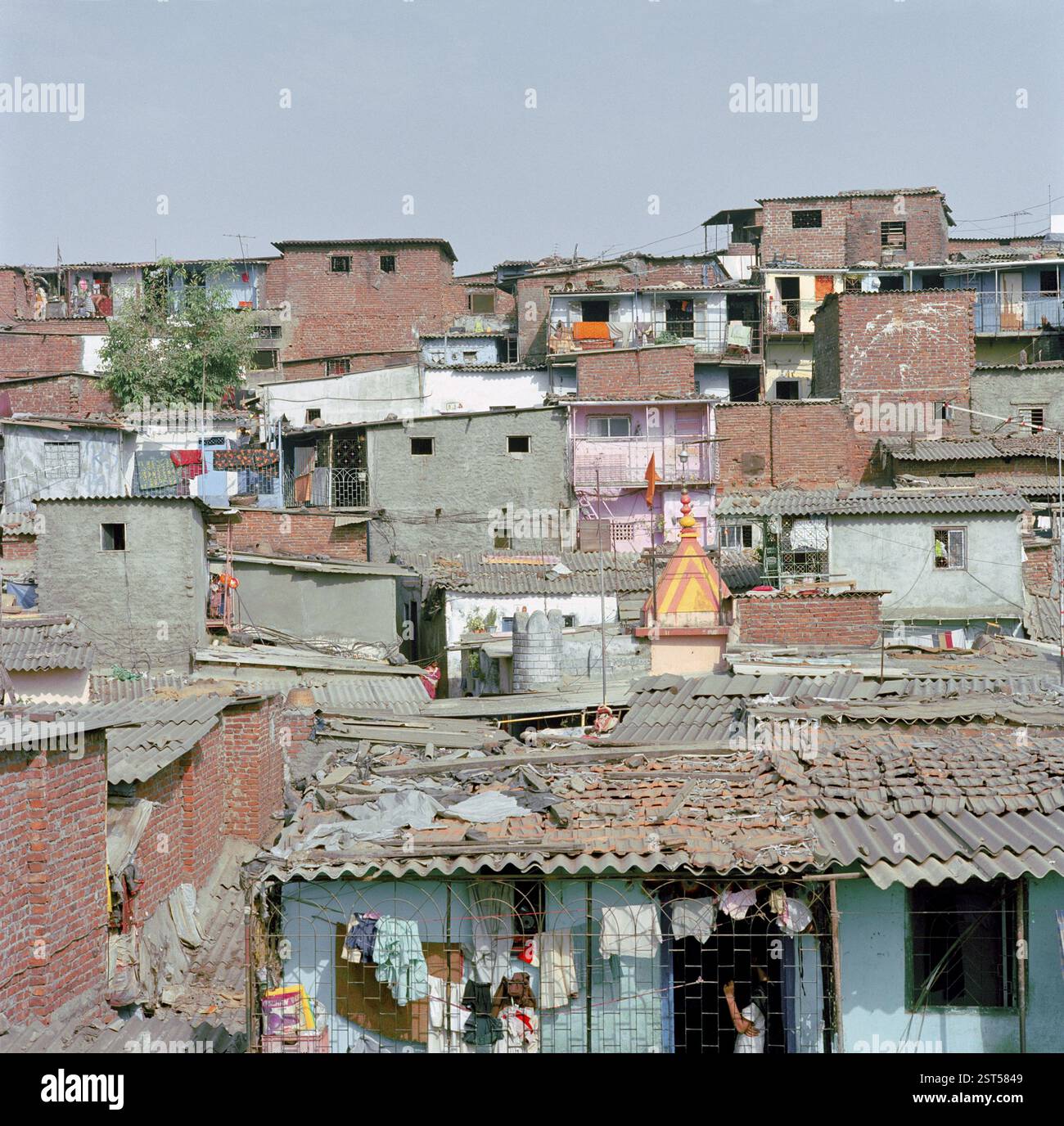 A view of A slum settlement on aslope with houses made of cheap and ...