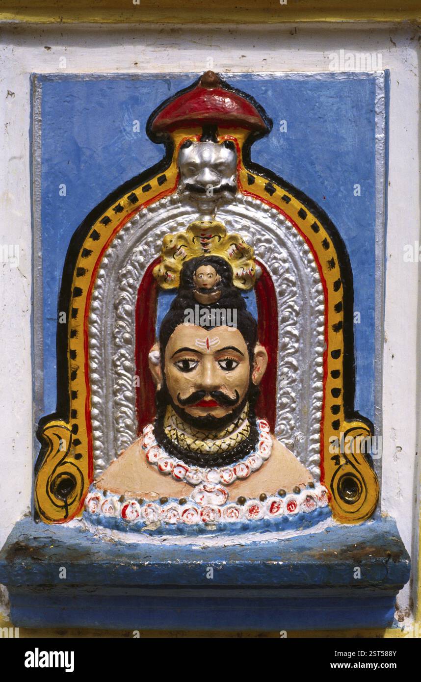 Lord Mangesh painted face on lamp tower, Mangeshi temple, Goa, India ...