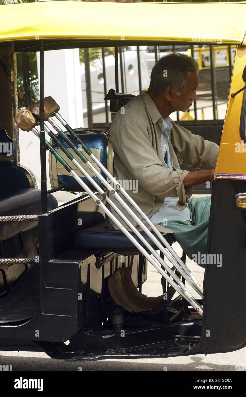 A physically handicapped rickshaw driver drives a auto rickshaw in ...