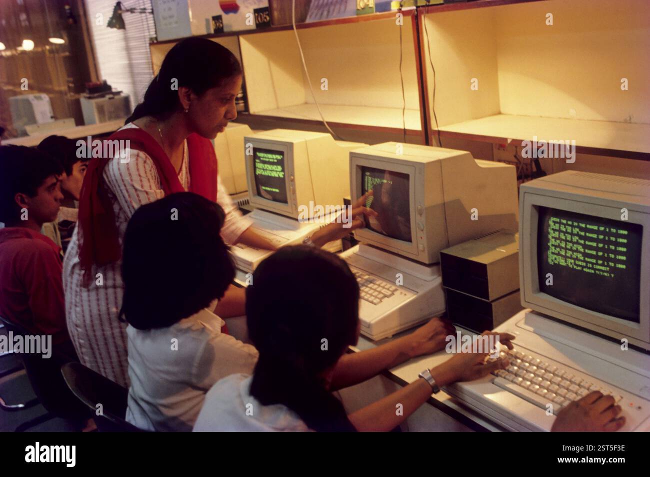 Children learning computer and teacher teaching Stock Photo - Alamy