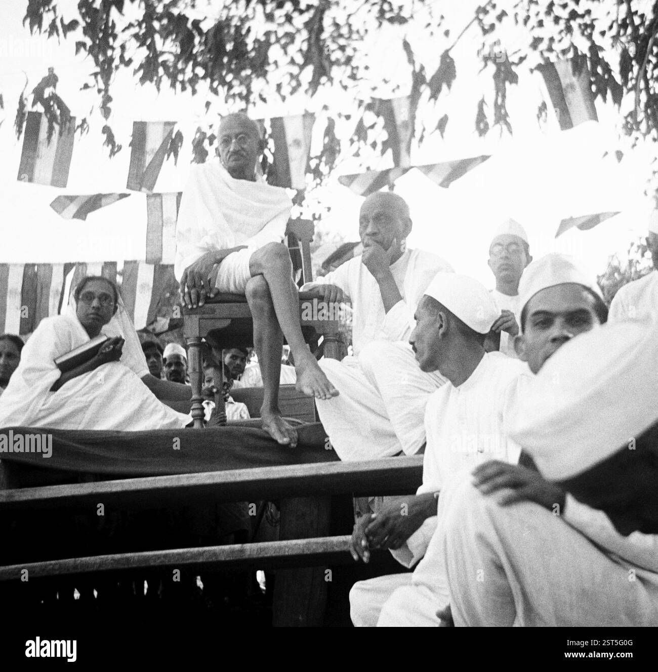 Mahatma Gandhi sitting with his coworkers at an evening meeting in ...