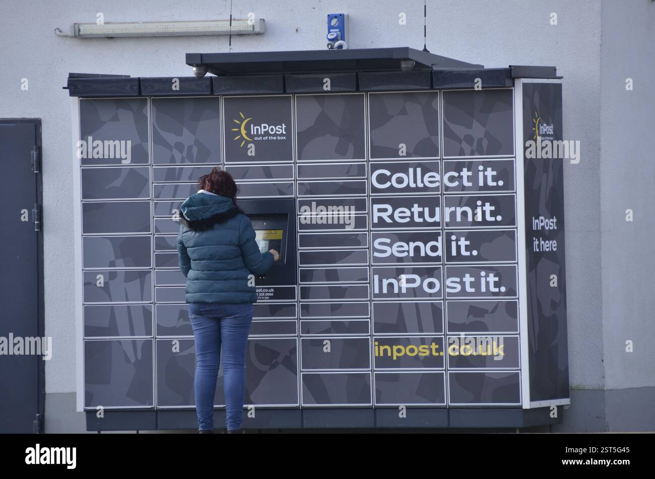 A woman using an InPost parcel locker at a Lidl store in Oakham ...