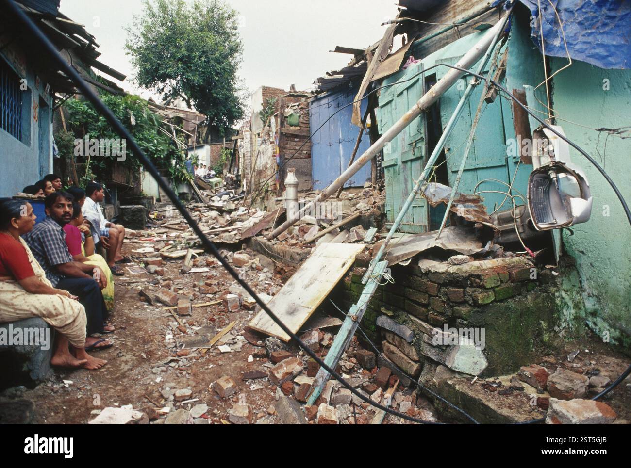 People sitting at slum demolition Stock Photo - Alamy