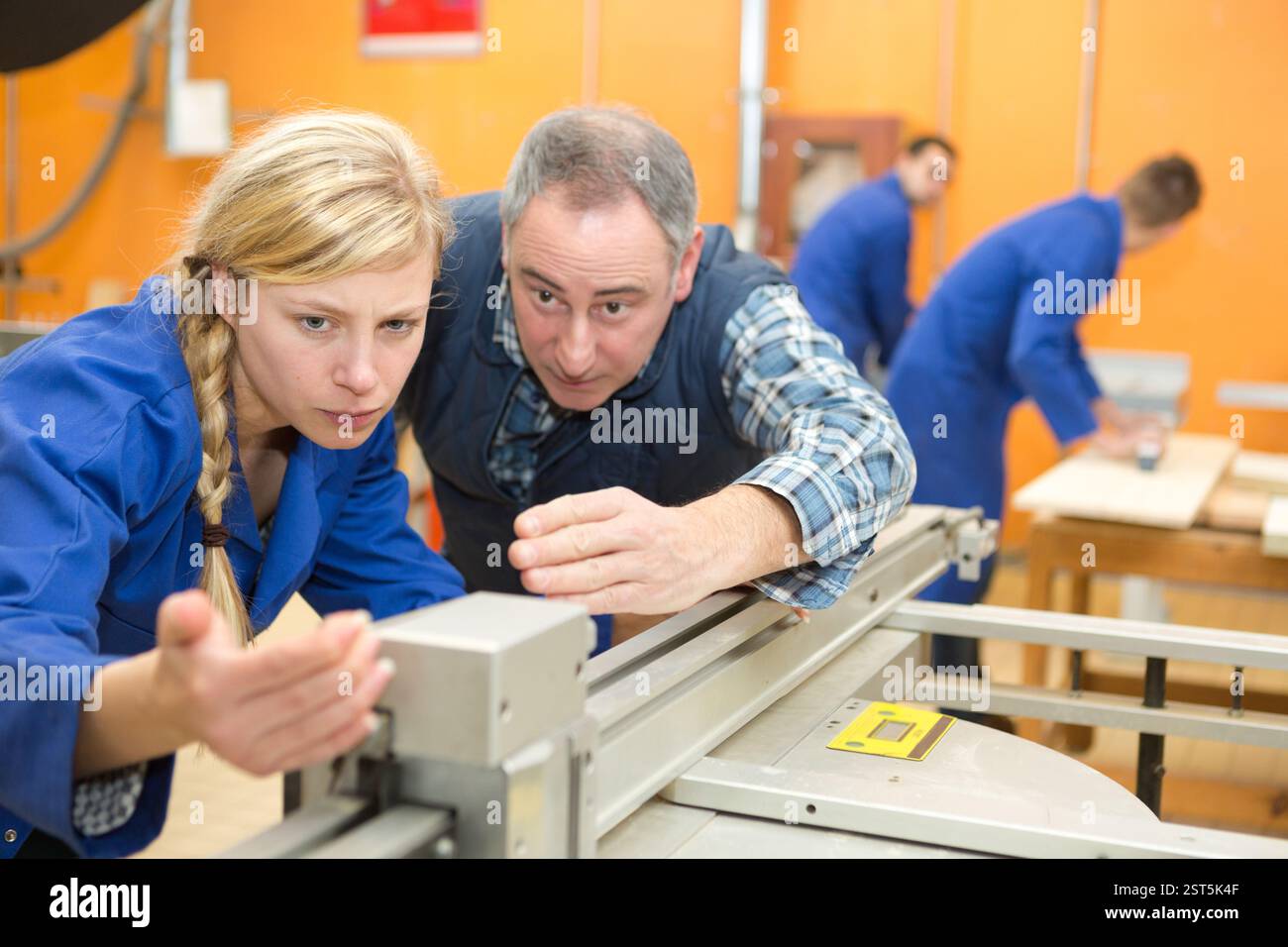 teacher explaining how to use machine in a woodwork class Stock Photo ...